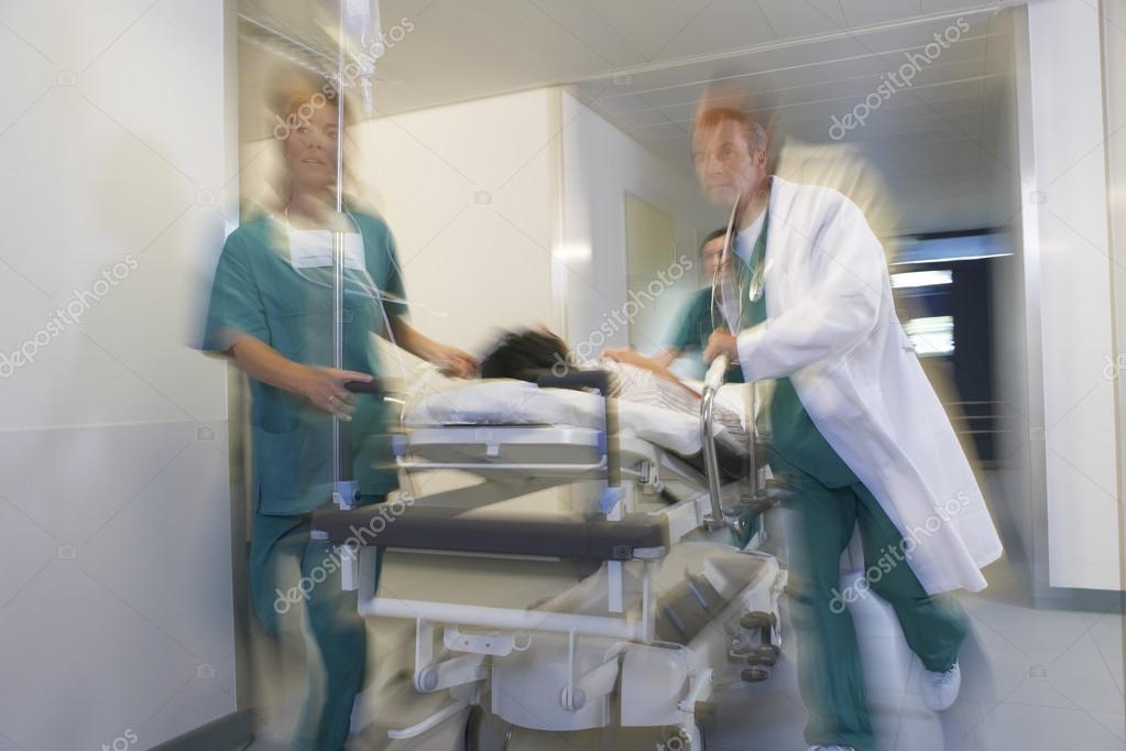 Doctors running Patient on gurney — Stock Photo © londondeposit #33848041