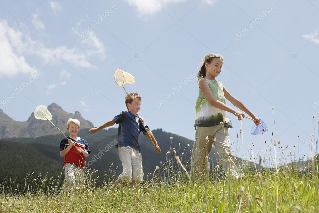 Kids Catching Bugs in Field Stock Photo by ©londondeposit 33849703
