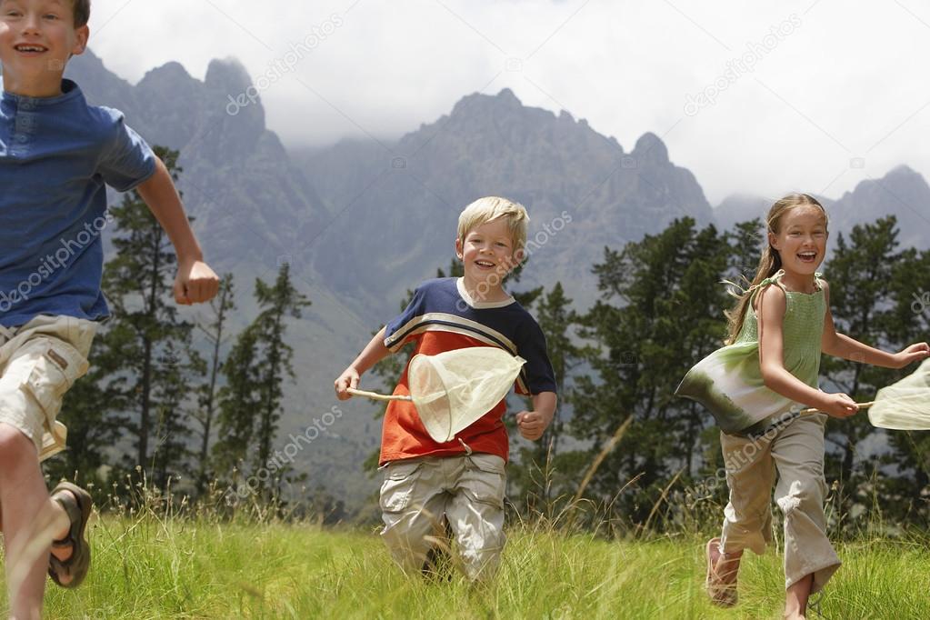 Kids Catching Bugs in Field Stock Photo by ©londondeposit 33850789