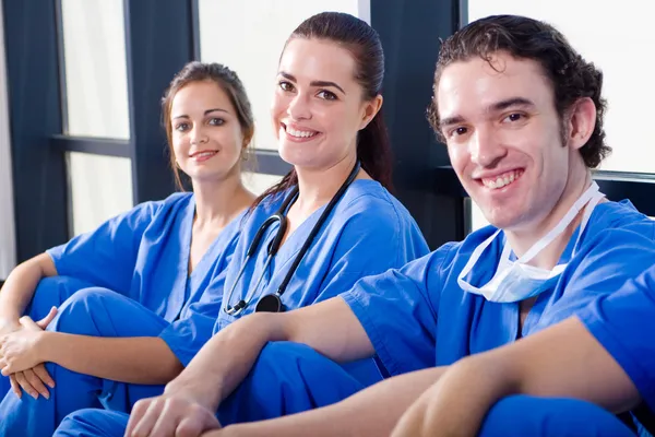 :two happy young medical nurses talking to each other during break ...