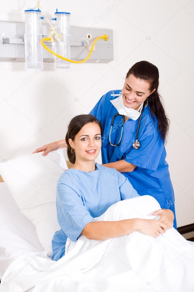 Friendly nurse helping hospitalized patient sitting up — Stock Photo ...