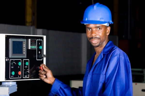 African male machine operator working on machine panel Stock Photo by ...