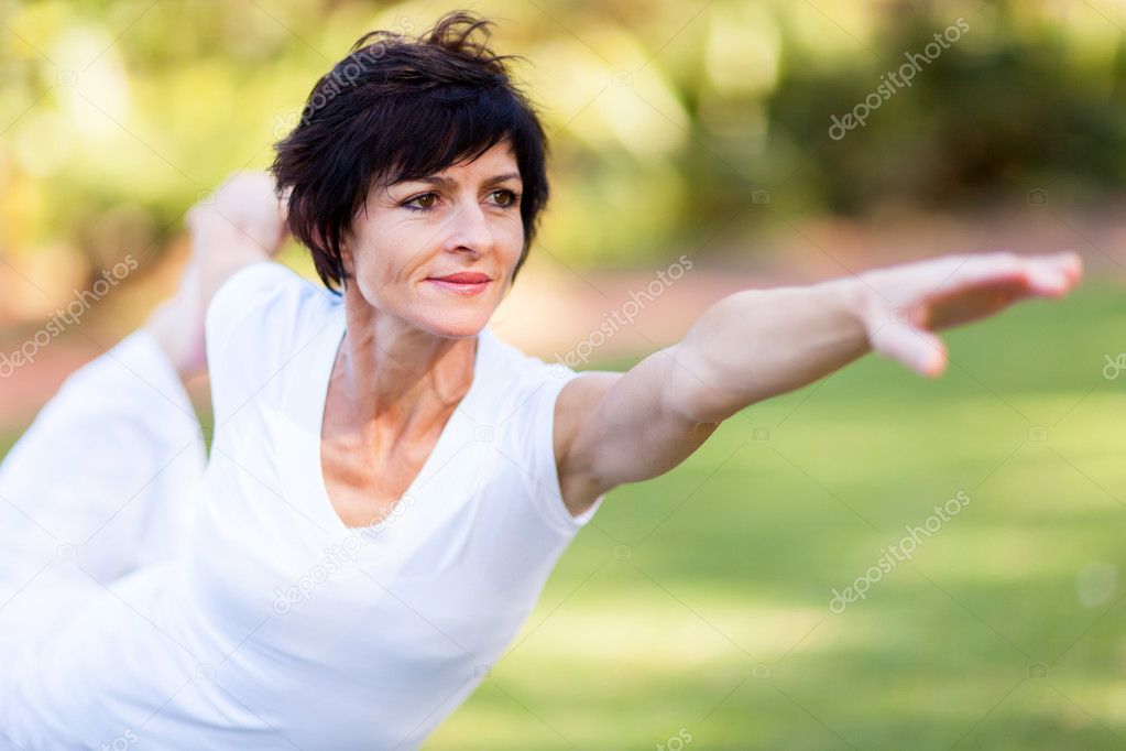 Healthy middle aged woman stretching outdoors — Stock Photo ...