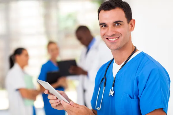 Handsome medical surgeon with tablet computer in hospital - Stock Image ...