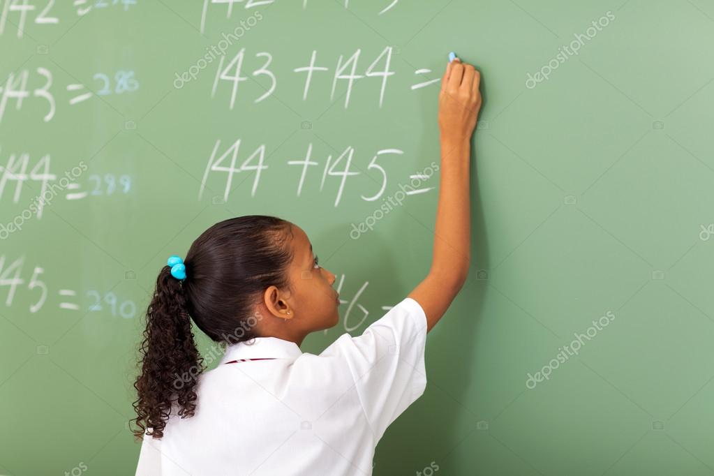 Primary school girl writing maths answer on chalkboard — Stock Photo ...