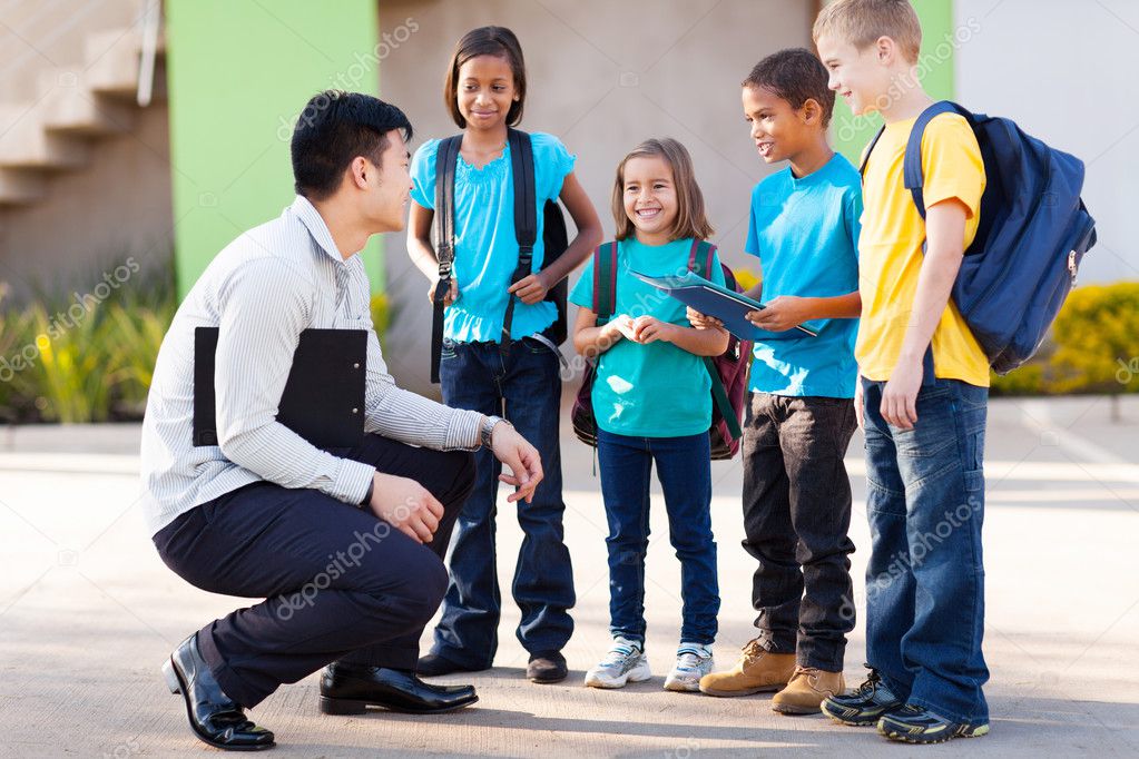 Elementary pupils outside classroom talking to teacher Stock Photo by ...