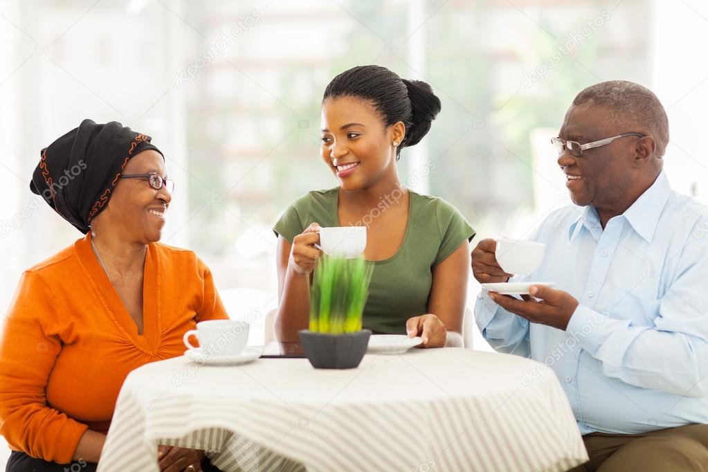 Senior african parents having coffee with daughter — Stock Photo ...