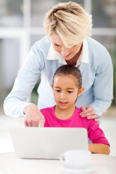 senior grandmother teaching grandchild computer - Stock Image - Everypixel