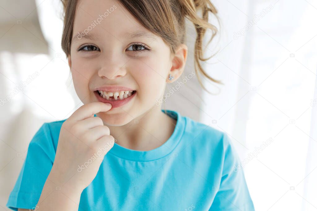 The child has lost a tooth. Little girl without a tooth. The first ...