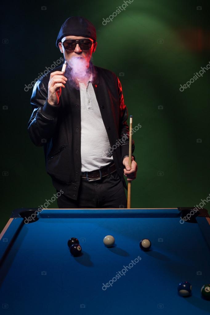 Man playing pool in a club smoking a cigarette Stock Photo by ...