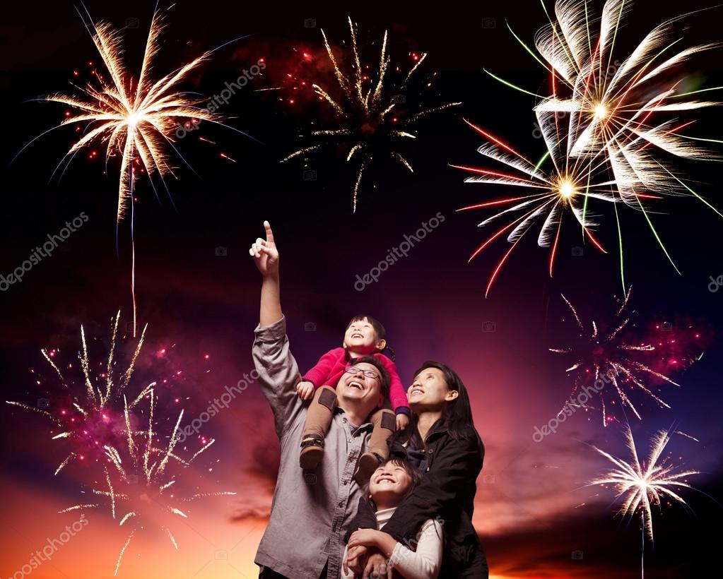 Happy family looking fireworks in the evening sky — Stock Photo ...