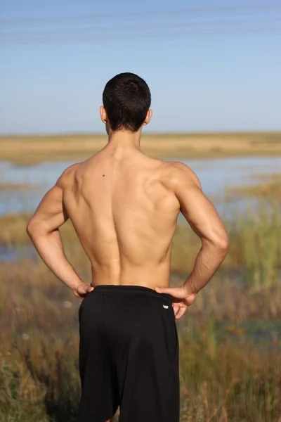 Male bodybuilder model back view Stock Photo by ©alexmillos 45987951