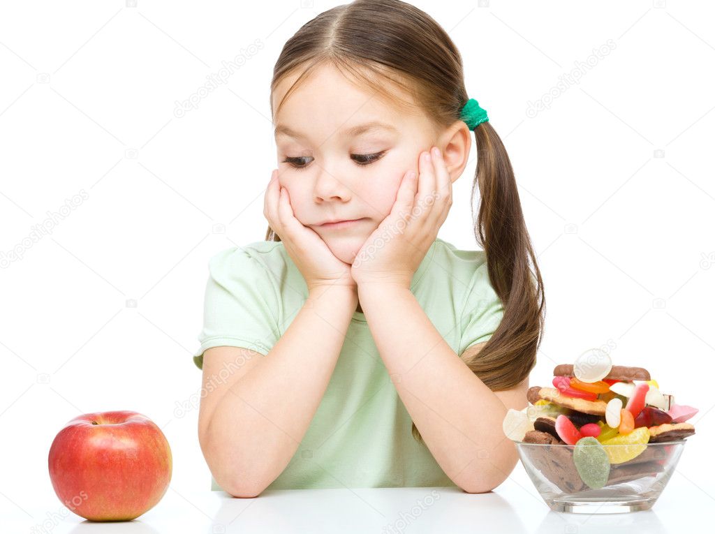 Little girl choosing between apples and sweets — Stock Photo © Kobyakov ...