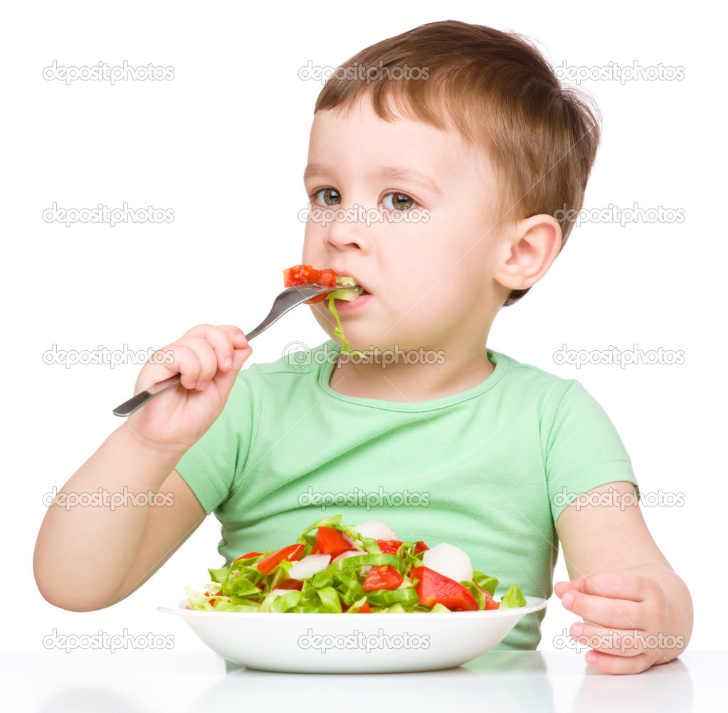 Cute little boy is eating vegetable salad Stock Photo by ©Kobyakov 26041149