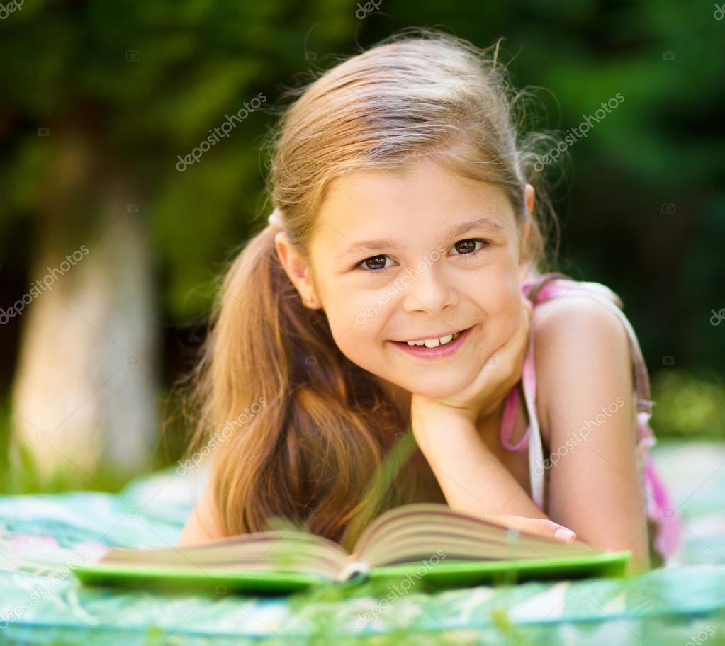 Little girl is reading a book outdoors — Stock Photo © Kobyakov #51466565