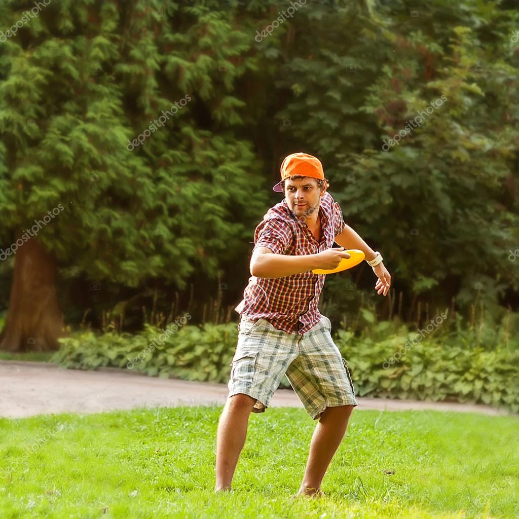Man playing in the park with a plate frisbee — Stock Photo © osons163 ...