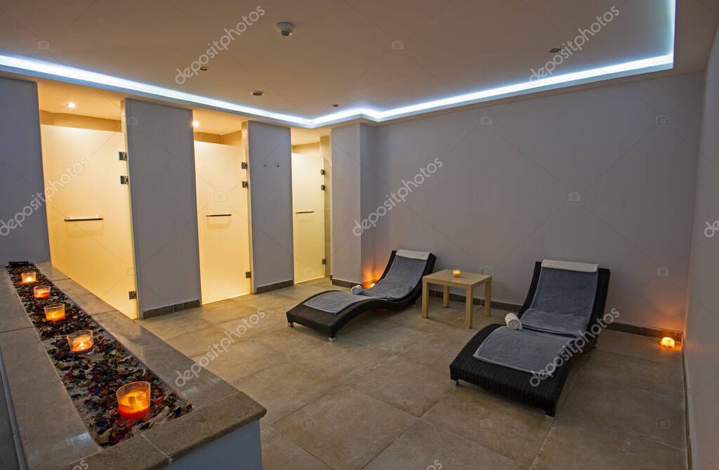 Zona de relax dentro de un spa de lujo con camas y toallas iluminadas ...