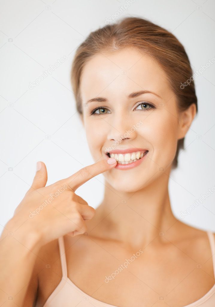 Beautiful woman pointing to teeth Stock Photo by ©Syda_Productions 13657907