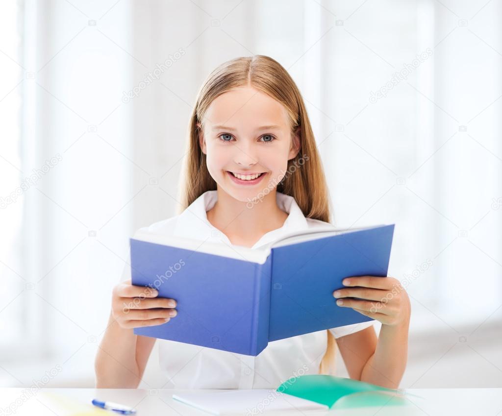Girl studying and reading book at school Stock Photo by ©Syda ...
