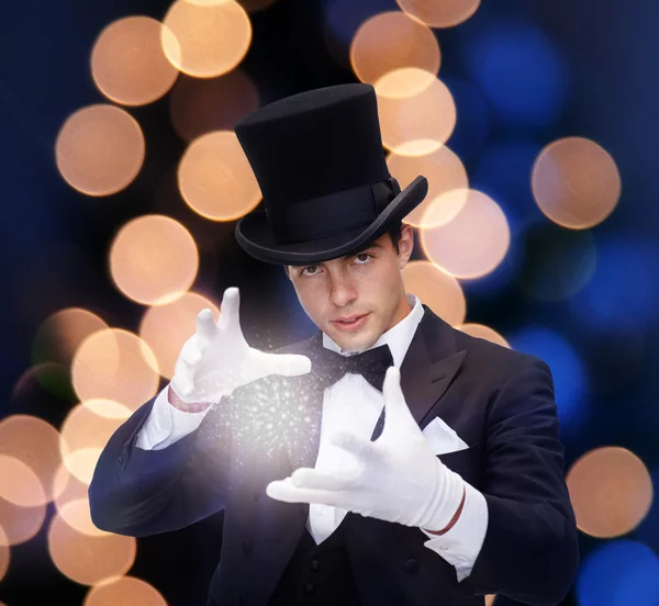 Magician in top hat showing trick - Stock Image - Everypixel