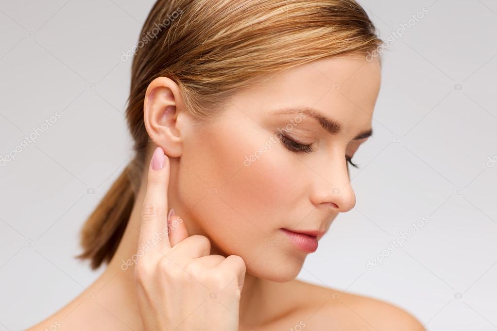 Calm woman touching her ear Stock Photo by ©Syda_Productions 40172079