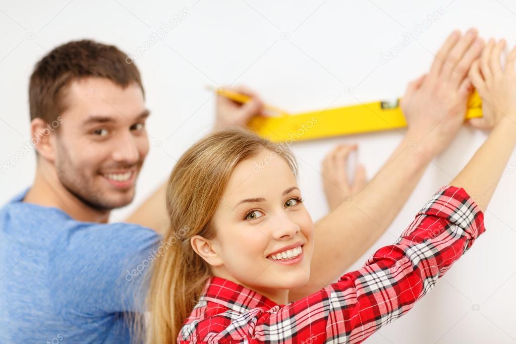 Couple building using spirit level to measure Stock Photo by ©Syda ...