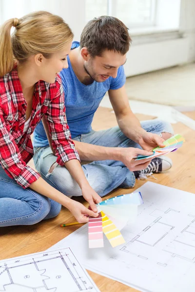 Smiling couple looking at color samples at home - Stock Image - Everypixel