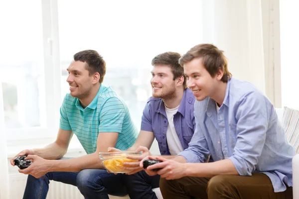 smiling friends playing video games at home - Stock Image - Everypixel