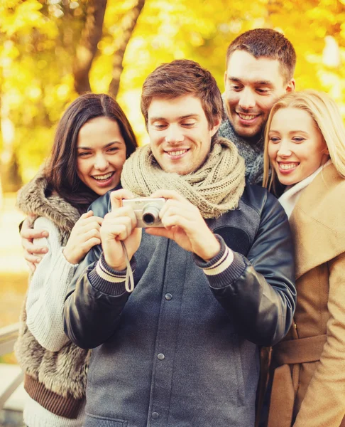 Group of friends with photo camera in autumn park - Stock Image ...