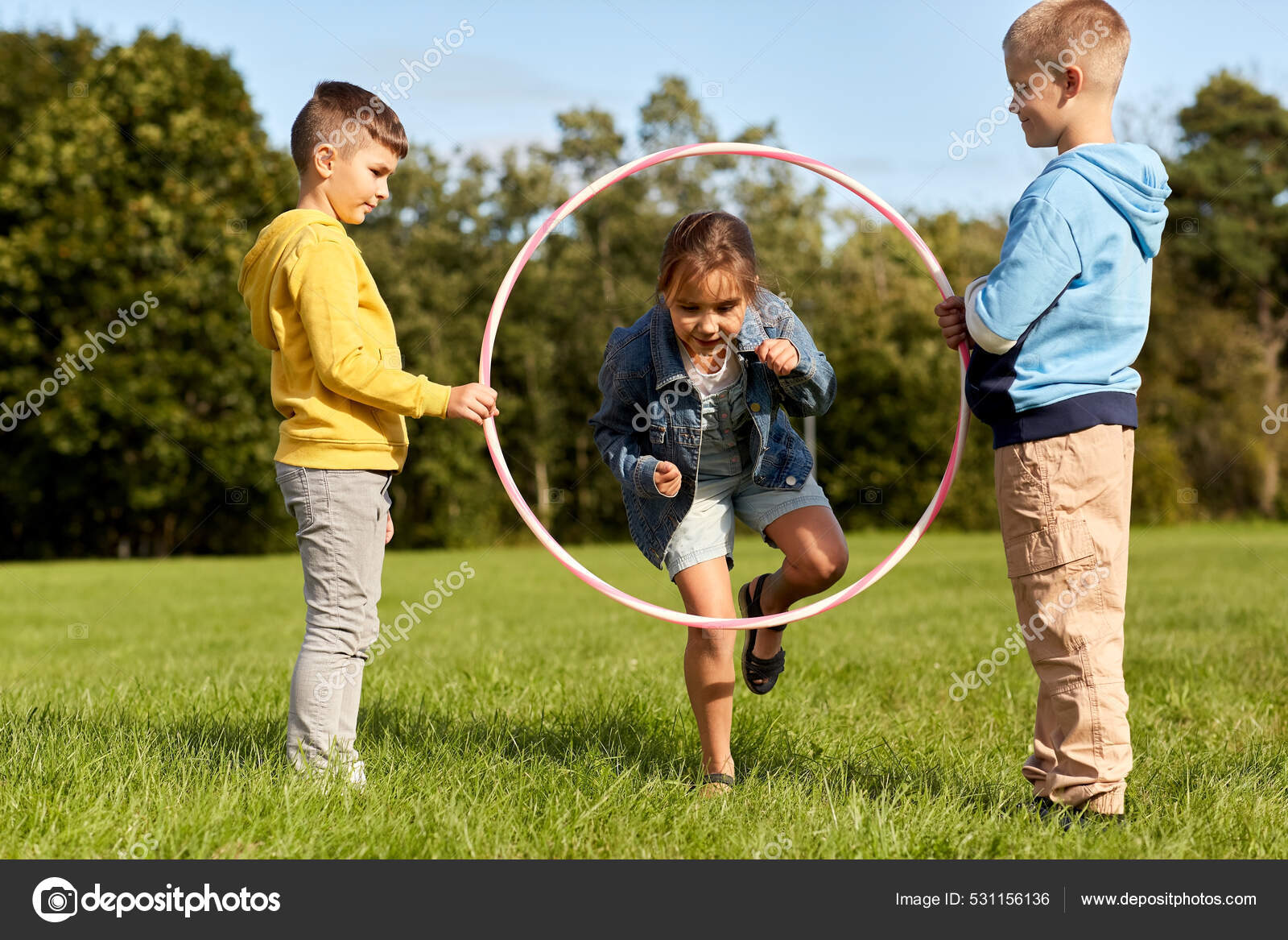 Niños felices jugando con hula hoop en el parque: fotografía de stock ...
