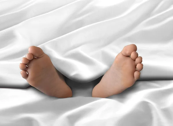 Feet under White Blanket and Bed Sheet - Stock Image - Everypixel