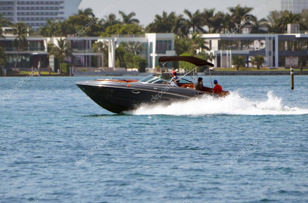 Lancha a motor de gama alta que pasa por delante de casas modernas de ...