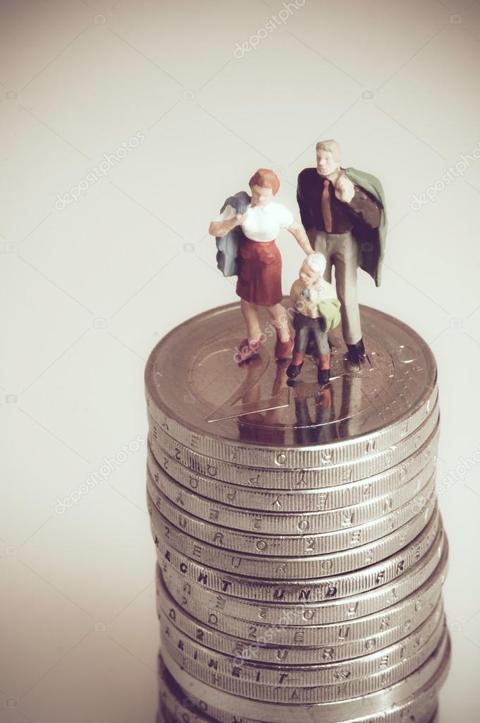 Miniature family on pile of coins. Stock Photo by ©KirillM 48842739