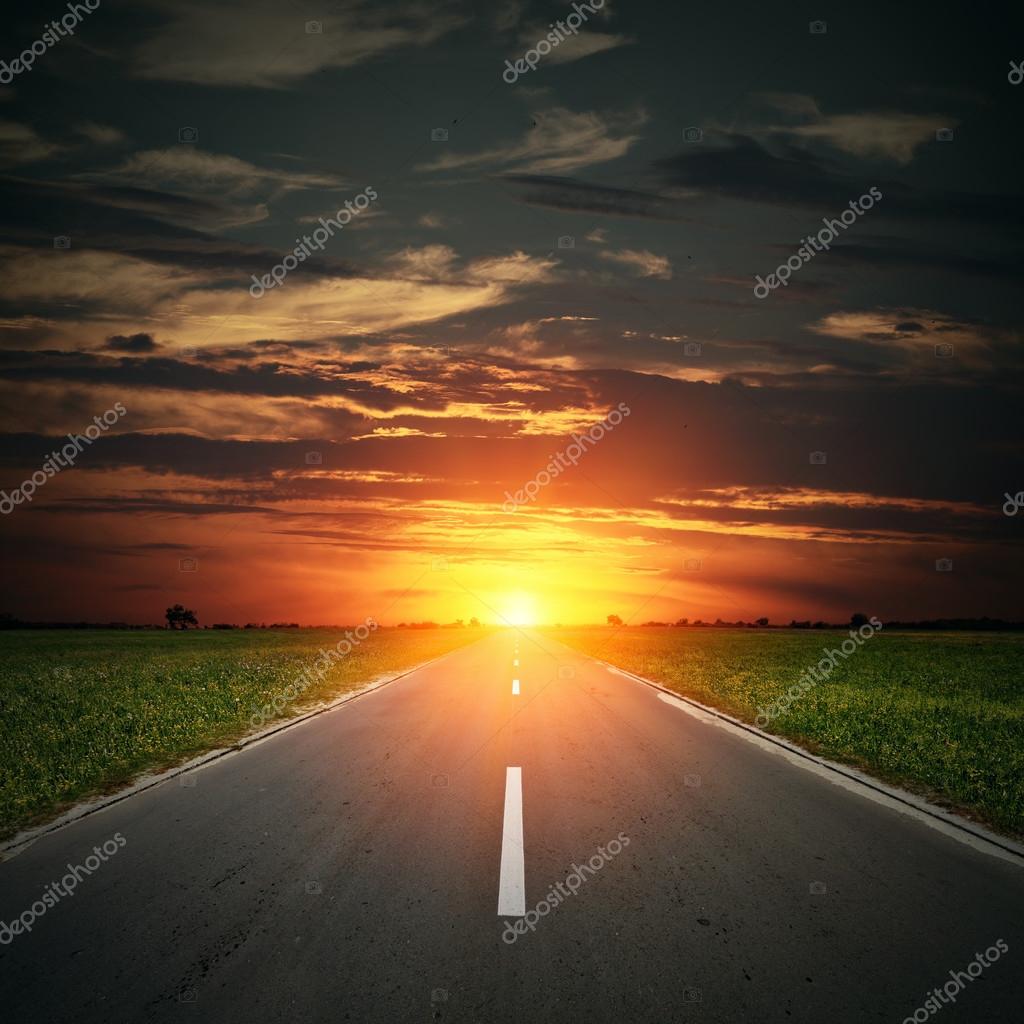 Route asphaltée vers l'horizon et le coucher du soleil image libre de ...