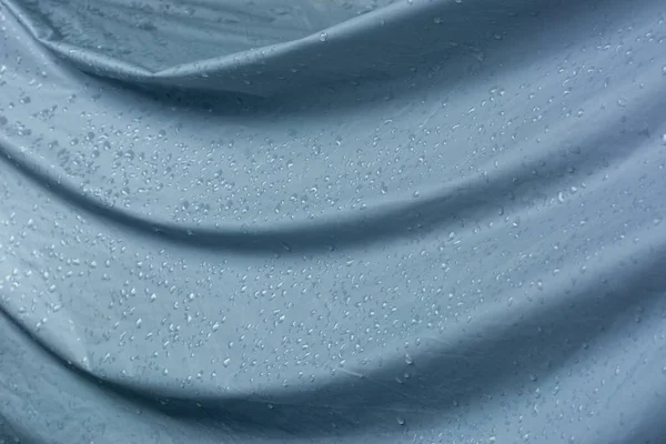 Wave pattern of pastel blue raincoat with water droplets. - Stock Image ...