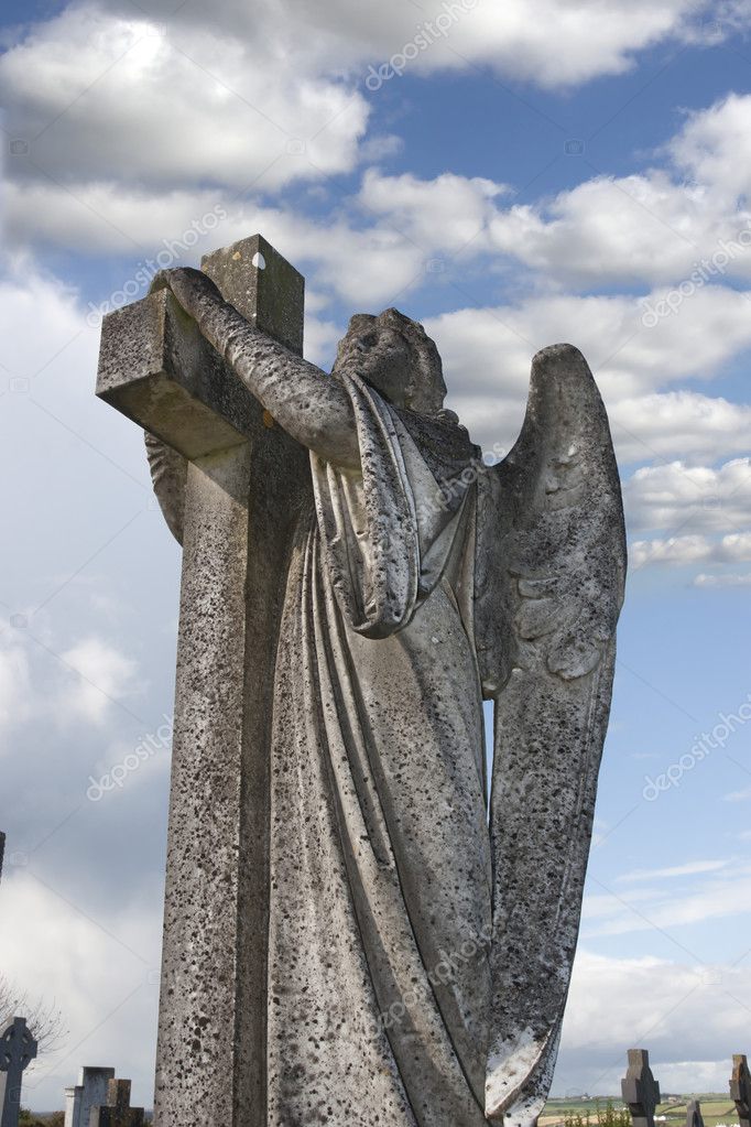 Angel statue embracing a cross — Stock Photo © morrbyte #24053017