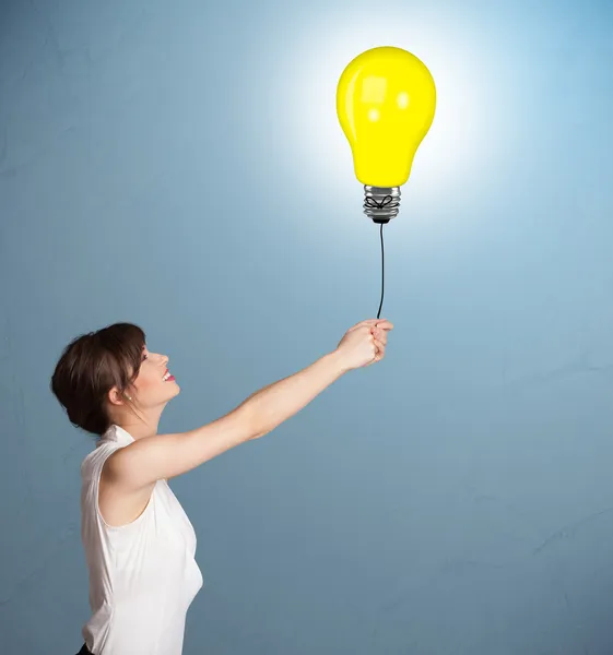 Pretty lady holding a light bulb balloon - Stock Image - Everypixel