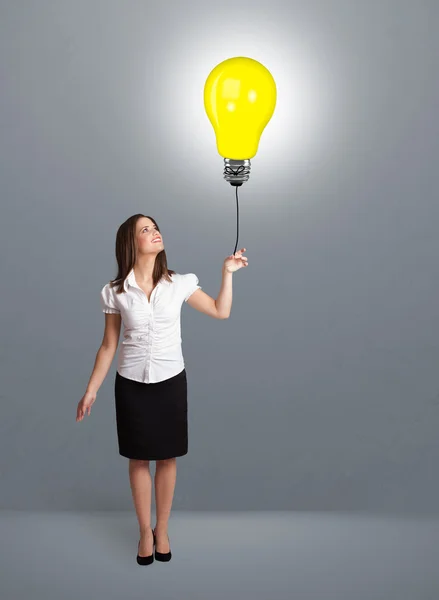 Pretty lady holding a light bulb balloon - Stock Image - Everypixel