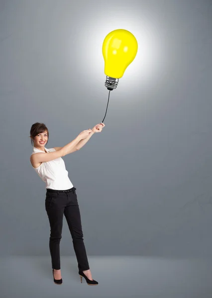 Pretty lady holding a light bulb balloon - Stock Image - Everypixel