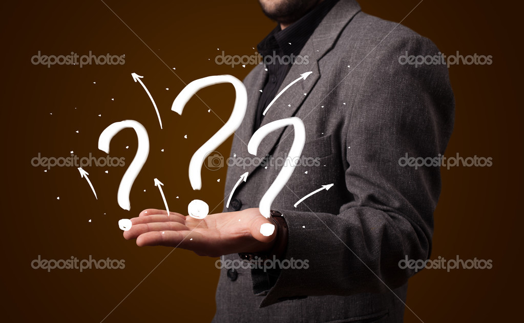 Fotos de Joven empresario que presenta signos de interrogación ...