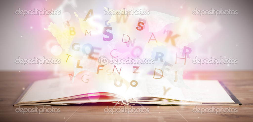 Libro abierto con letras brillantes sobre fondo concreto: fotografía de ...