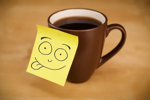 Post-it note with smiley face sticked on a cup - Stock Image - Everypixel