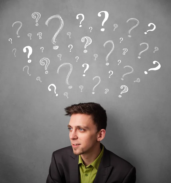 Fotos de Joven empresario que presenta signos de interrogación ...