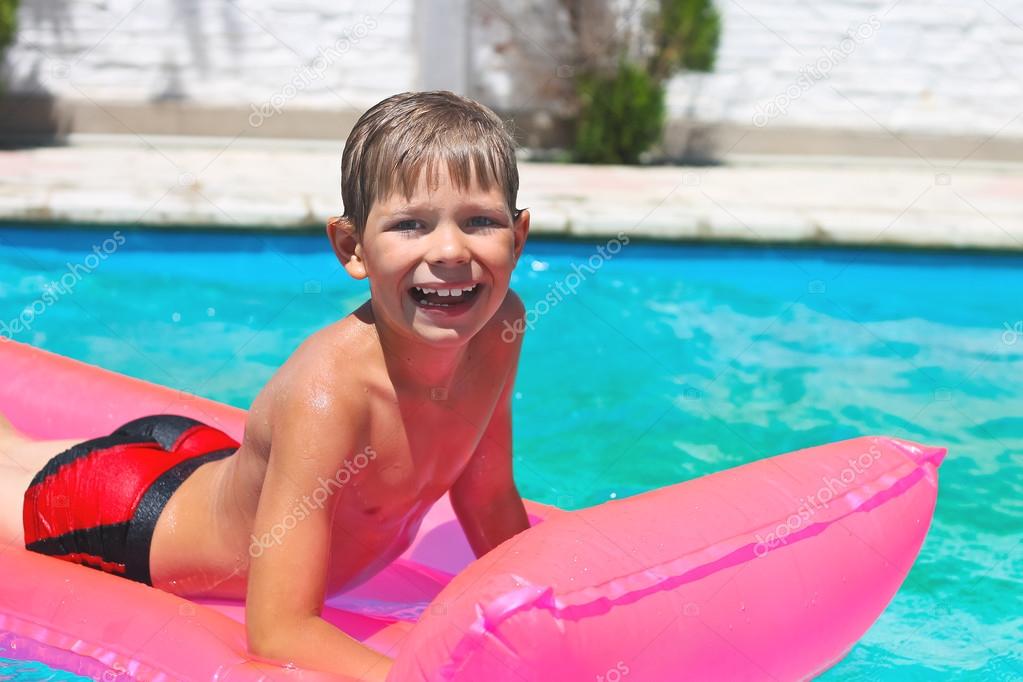 Smiling boy lies on pink mattress in the pool — Stock Photo © Nicknick ...
