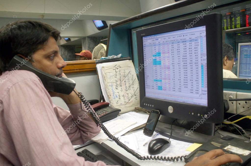 A Pakistani trader monitors trade prices at Karachi Stock Exchange (KSE), in Karachi – Stock ...