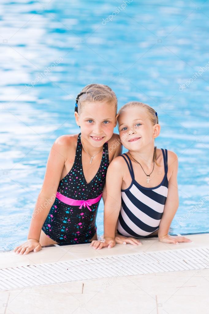 Two cute little girls in swimming pool Stock Photo by ©Len44ik 50303763
