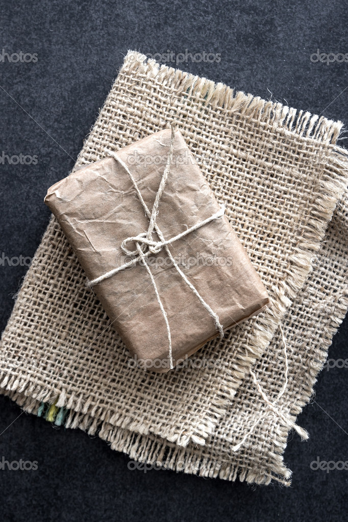 Package wrapped in wrinkled brown paper lying on weathered wood Stock ...