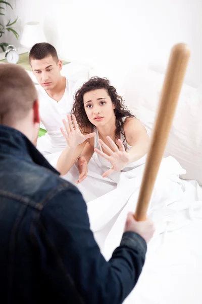 Caught cheating, angry husband holding the baseball bat, a woman ...