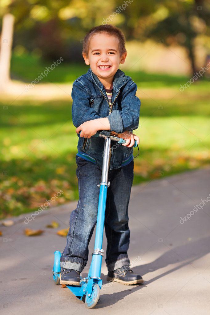Laughing boy with scooter — Stock Photo © icefront #33319971