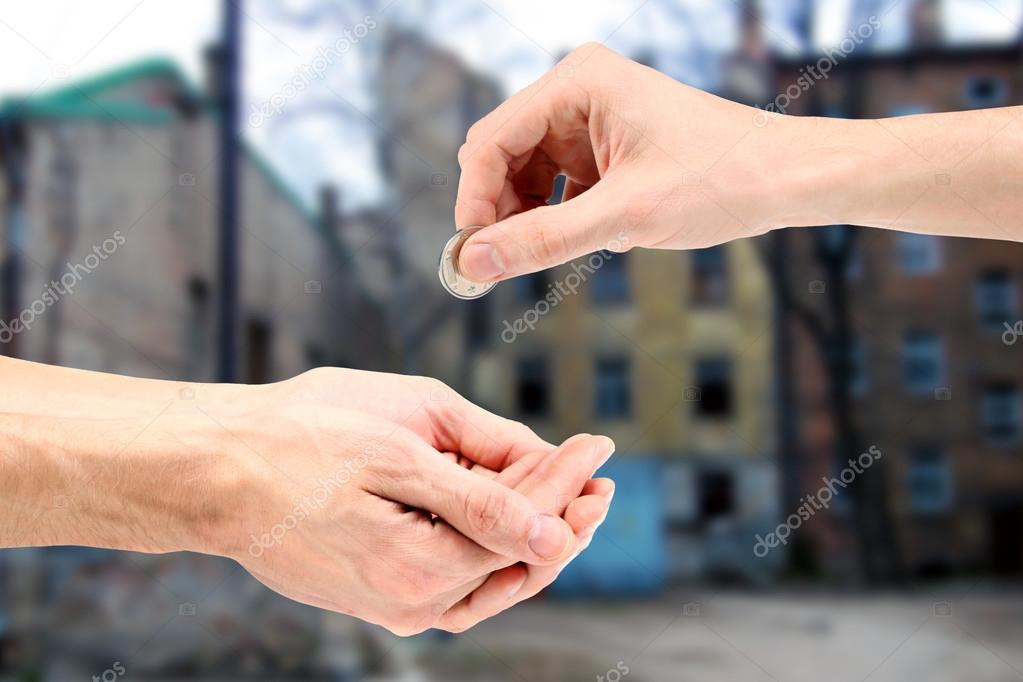 La mano da moneda al mendigo en la calle 2024